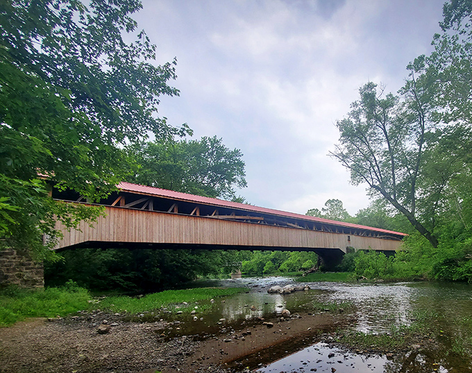 Where history meets tranquility: The bridge's weathered wooden sides reflect in Tuscarora Creek's gentle waters below.