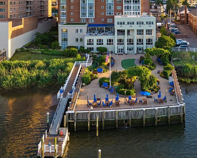 Riverside relaxation at its finest&mdash;blue umbrellas, manicured gardens, and waterfront views create an urban oasis where stress simply floats away.