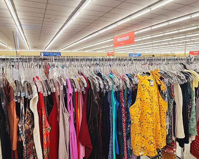 A rainbow of possibilities hangs in perfect formation. Each garment tells a story, waiting for its next chapter to begin in someone else's closet. 