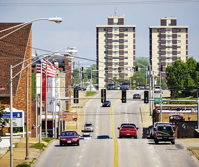 The long, winding street and those distant high-rises create a dynamic view, a blend of city and small-town life.