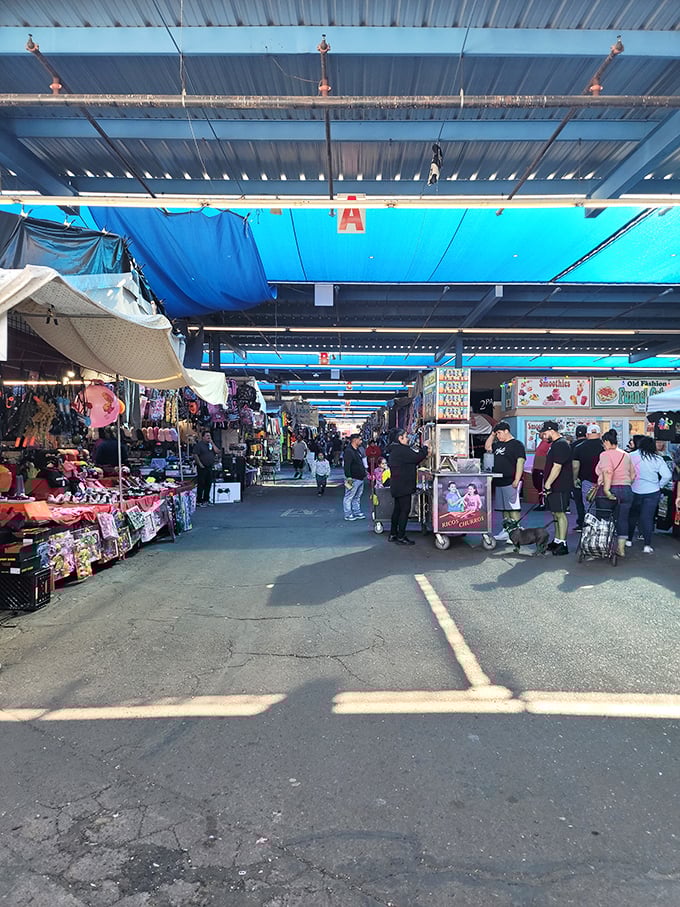 The market's blue canopy creates a cool oasis for shoppers. Desert sun above, desert deals below!