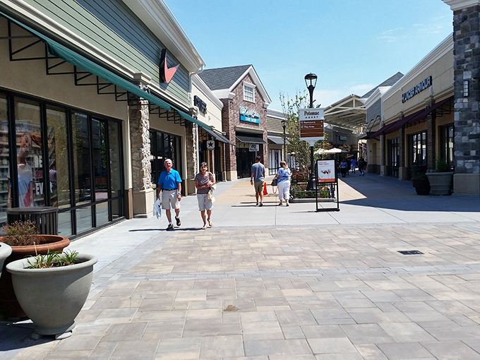 Sunshine bathes the clean walkways of Norfolk Premium Outlets, where shoppers stroll between deals in this outdoor shopping haven.