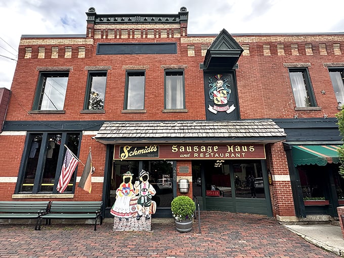 The historic brick facade of Schmidt's Sausage Haus welcomes hungry visitors with old-world German charm. Those cutout figures are just a preview of the fun waiting inside!