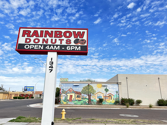 The classic donut shop sign stands tall like a beacon for sugar seekers everywhere. 