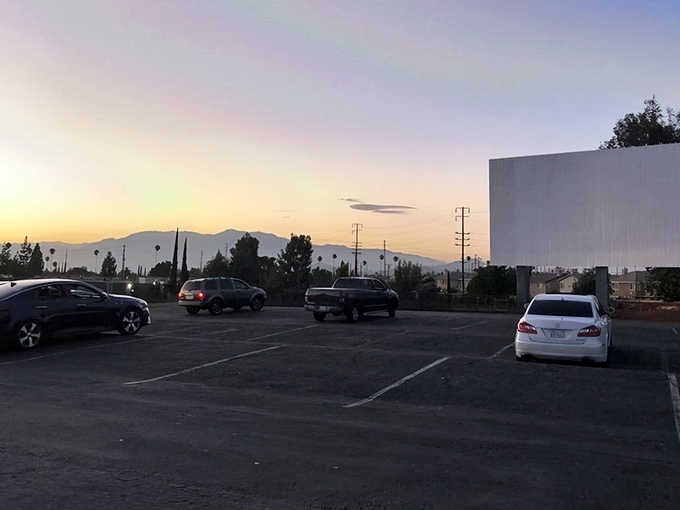 Mountains frame this cinematic cathedral at Van Buren Drive-In, where empty spaces will soon fill with moviegoers chasing that perfect California evening.