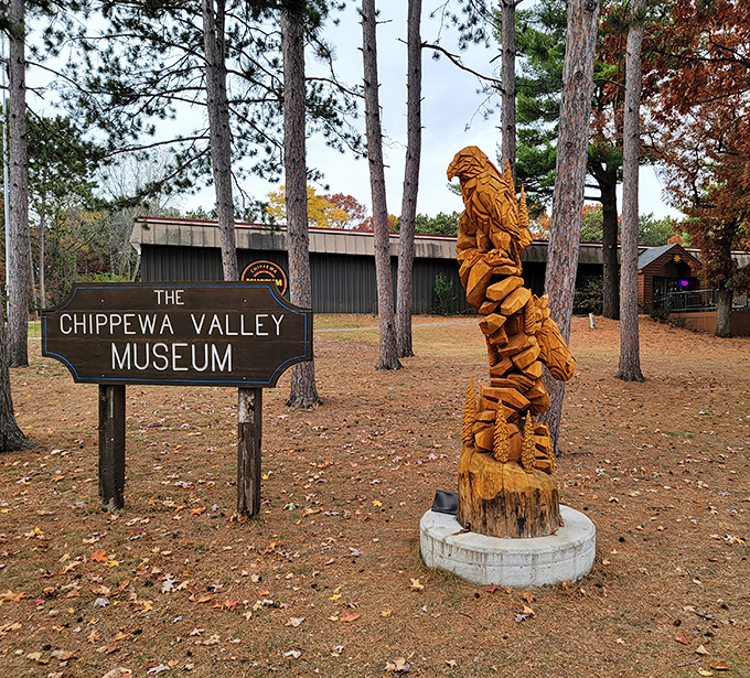 The Chippewa Valley Museum's wooden sculpture stands guard like a friendly forest spirit, welcoming visitors to discover the region's rich history among the pines.