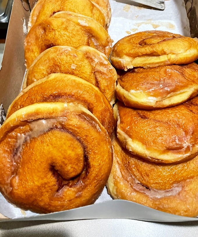 Behold the holy grail of pastry perfection – Oram's legendary cinnamon rolls glisten with glaze, each spiral promising a journey to carbohydrate nirvana.