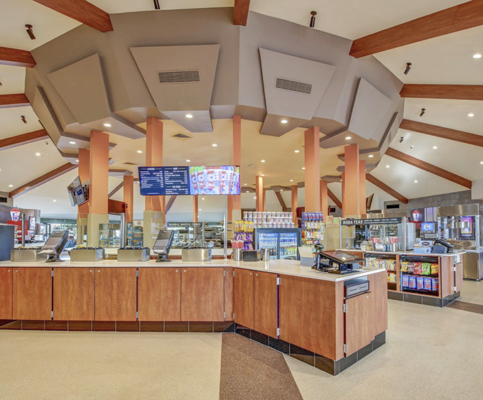 Inside the concession area, modern efficiency meets mid-century charm. The wood-paneled counter practically whispers, "Yes, you deserve that extra candy."