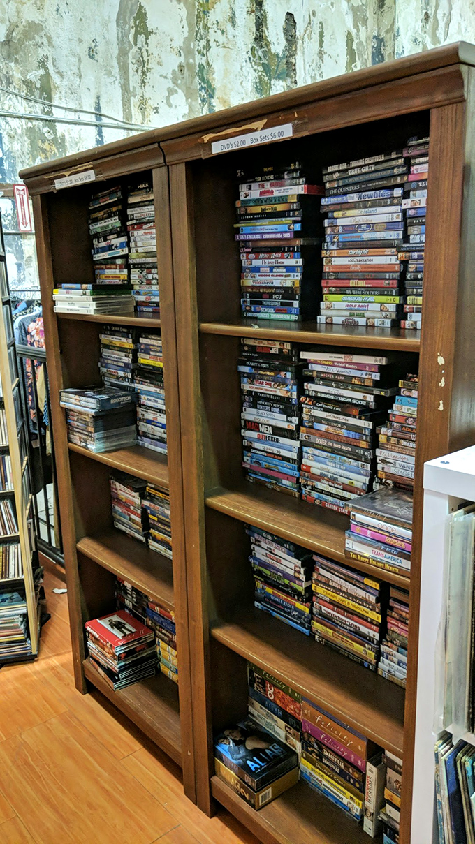 DVDs stacked like memories in wood &ndash; your entire Netflix queue before streaming ruined everything.