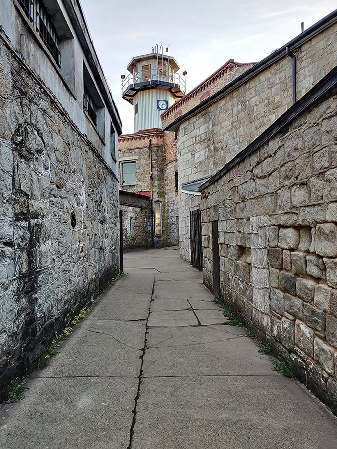 Between these imposing stone walls, a guard tower looms overhead like a watchful sentinel, still standing guard over ghosts of the past.