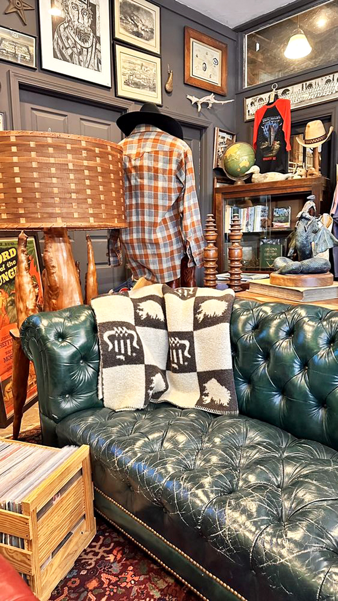 A tufted green leather sofa invites you to sit and contemplate your next vintage acquisition, surrounded by vinyl records and nostalgic charm.