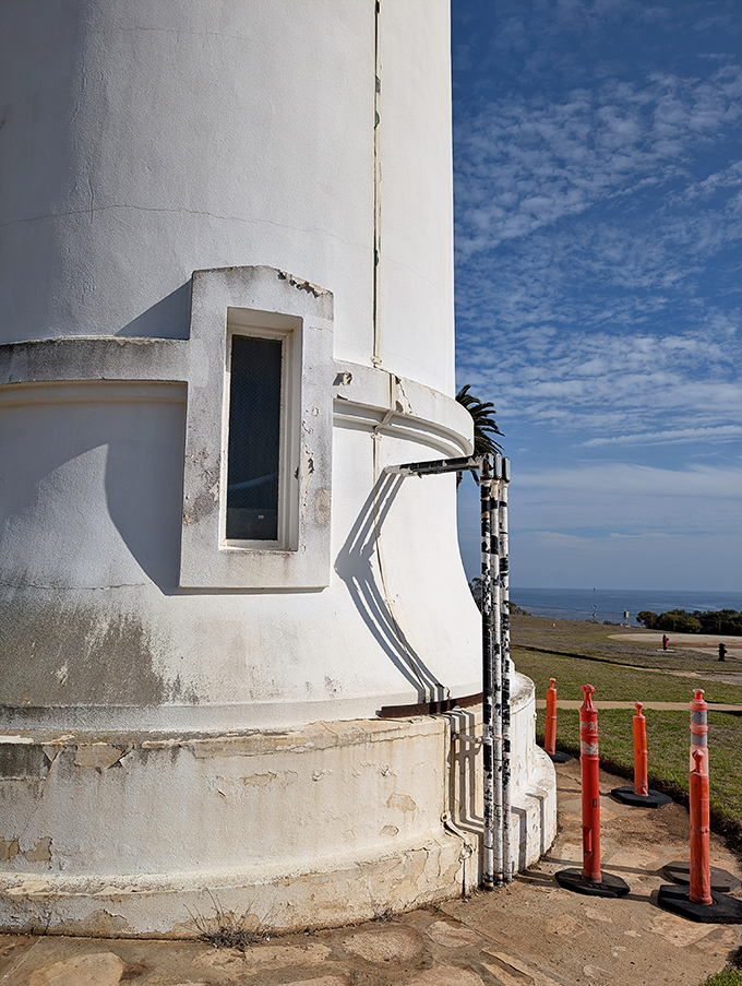 Even lighthouses need plumbing! The utilitarian meets the majestic where infrastructure and inspiration converge against that perfect California sky.