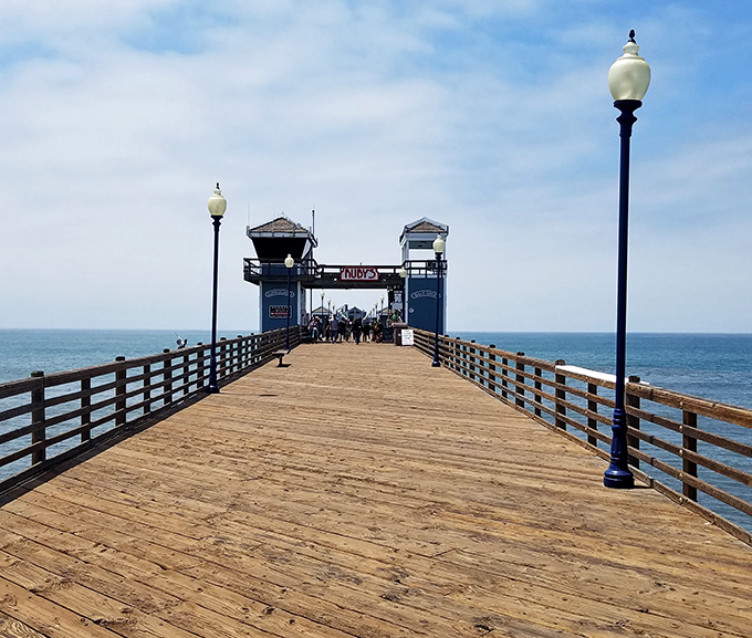 Walking this wooden walkway feels like stepping into a California postcard—complete with vintage lampposts that have witnessed countless first kisses and marriage proposals.