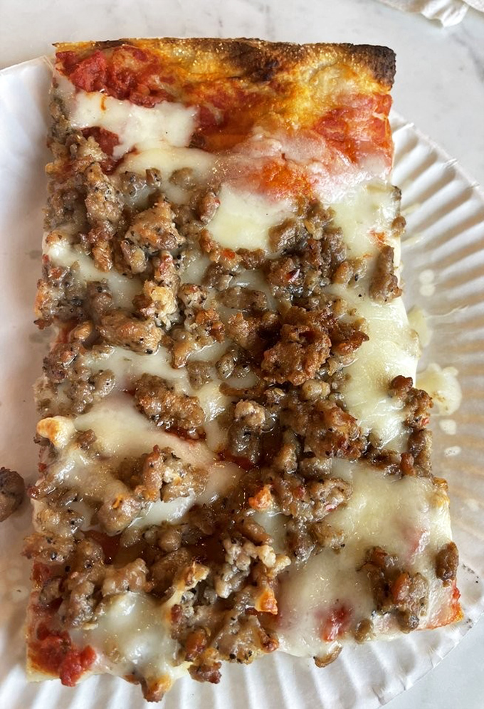 This isn't just pizza&mdash;it's a commitment. The sausage-topped slice has that perfect cheese pull that haunts your dreams long after lunch is over.