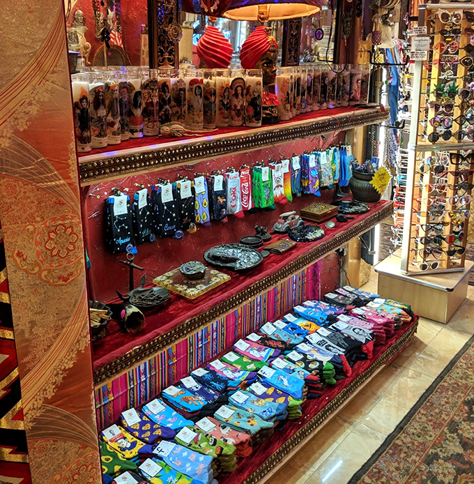 Colorful socks, devotional candles, and quirky accessories line shelves in a retail display that's part boutique, part cabinet of curiosities.