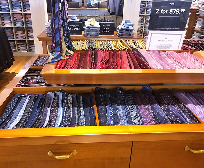 A rainbow sea of neckwear at what appears to be Brooks Brothers, where ties aren't just accessories but personality statements waiting to be made at 60% off retail.