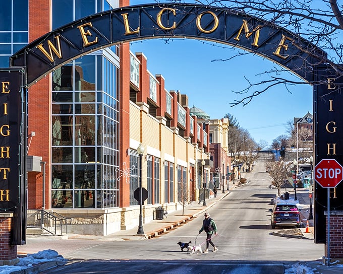 Winter sunlight bathes the Welcome Arch as a local walks their dog, creating that perfect small-town moment Norman Rockwell would've scrambled to paint.