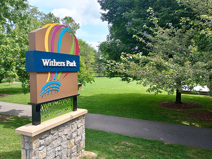 Withers Park offers a peaceful green escape in the heart of town, where rainbow-colored signage promises recreation without an admission fee.