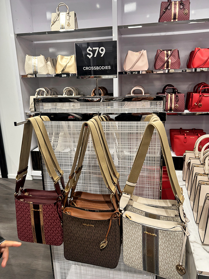 Designer crossbodies hang like forbidden fruit, tempting you to whisper "just one more bag" to your increasingly suspicious travel companions.