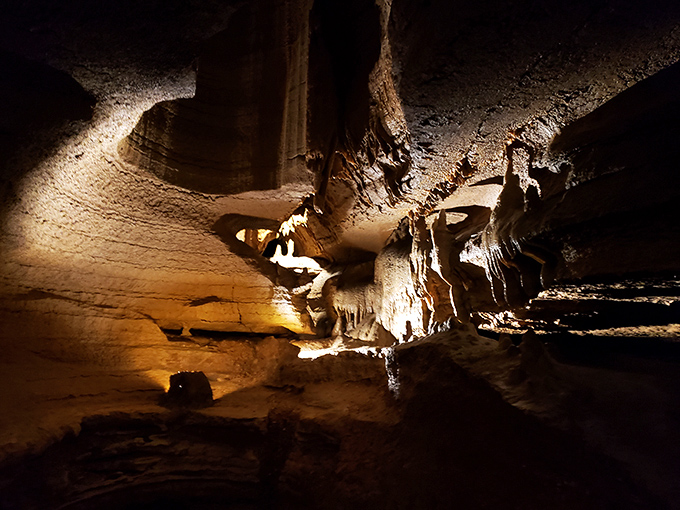 Sunlight rarely penetrates these depths, but strategic lighting reveals the cave's golden hues and dramatic textures that took millennia to perfect.