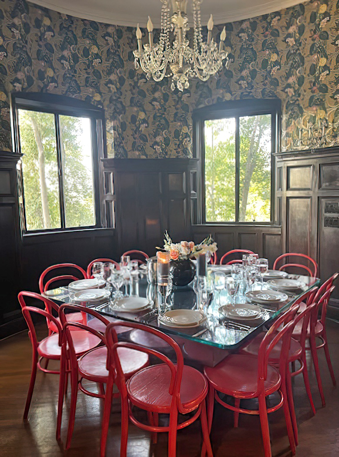 Floral wallpaper meets crystal chandelier in this dining room, where those bold red chairs aren't just making a statement&mdash;they're delivering a full-on design TED talk.