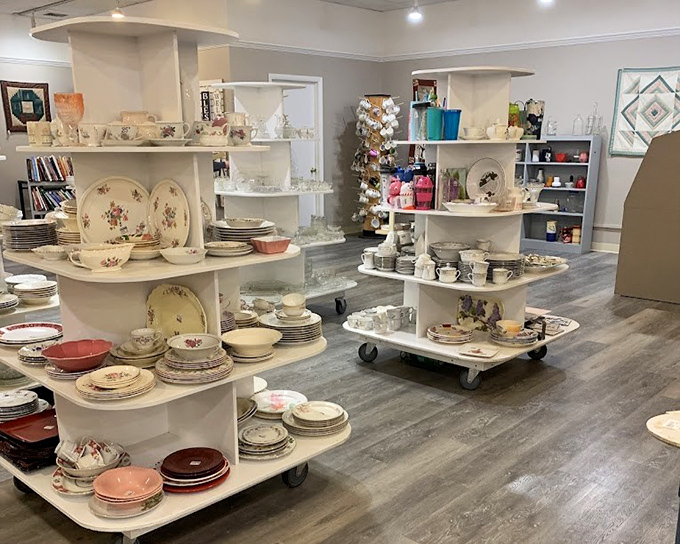 An inviting display of vintage and floral dinnerware awaits bargain hunters inside this cozy thrift store. Perfect finds for those who love unique table settings and affordable treasures!"