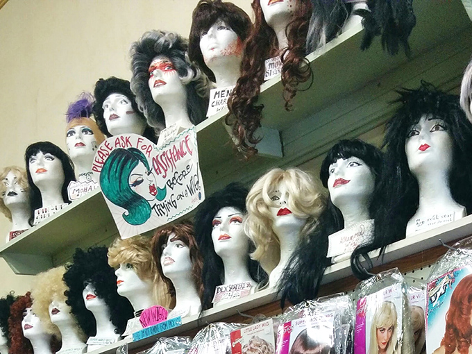 The silent audience of mannequin heads watches shoppers with painted expressions, each wig telling a different story waiting to be continued.