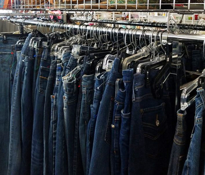Denim dreams hanging in neat rows. Each pair tells a story, waiting for its second act in someone else's wardrobe revolution.