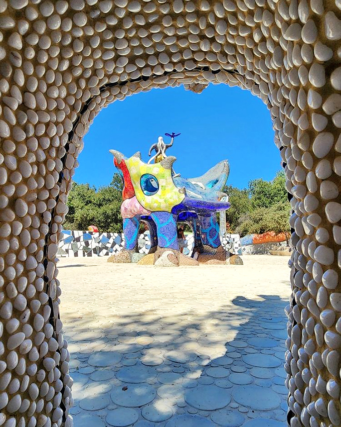 Peek-a-boo perfection! The pebbled archway frames the magical world beyond like a portal to another dimension where imagination reigns supreme.