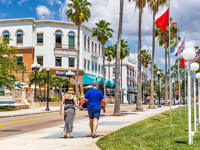 Main Street invites strolling couples to discover local shops and restaurants, with palm trees standing sentinel like nature's own welcome committee.