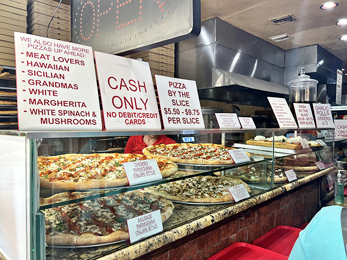 CASH ONLY declares the sign above a tempting display of New York-style pizza. Some traditions, like perfect pizza and paper currency, never need upgrading.