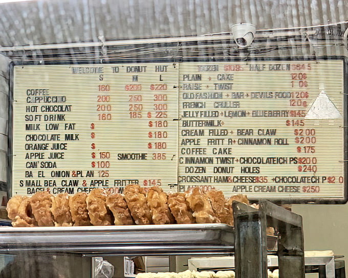 The menu board at Donut Hut is like a treasure map to happiness. No fancy fonts or pretentious descriptions&mdash;just straightforward paths to satisfaction.