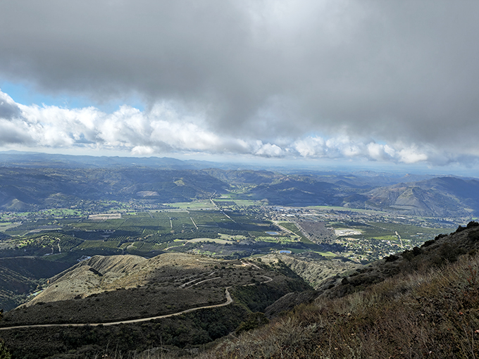 Rolling clouds drift over Palomar Mountain State Park, opening up breathtaking views of the valley below with winding trails and endless greenery.
