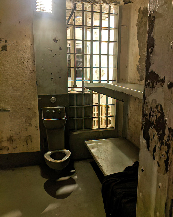 Privacy was a foreign concept here. This spartan cell offered nothing but the basics&mdash;a metal bed, institutional toilet, and the constant reminder that freedom was just beyond those bars.