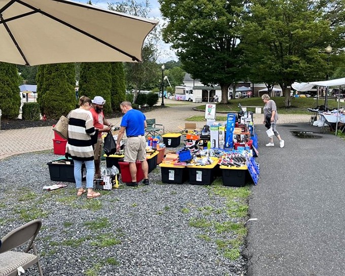 The outdoor market transforms into a social hub where strangers become friends over mysterious gadgets and unexpected bargains.