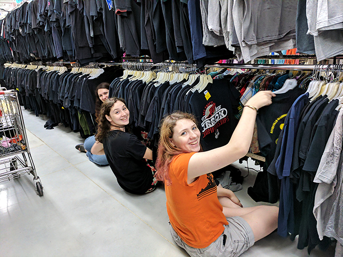 Thrift store archaeology at its finest! These shoppers have mastered the floor-level search technique &ndash; the mark of true secondhand professionals.