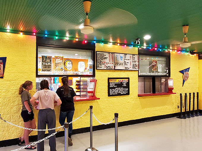 Step into a time capsule of Americana with the Stardust's vibrant yellow concession stand, where string lights and movie nostalgia create the perfect pre-show atmosphere.