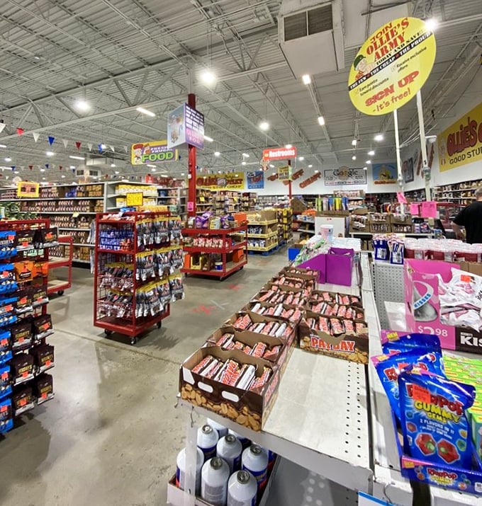 Inside, aisles stretch like urban canyons of cardboard and plastic, with colorful signs guiding bargain explorers through the retail wilderness.