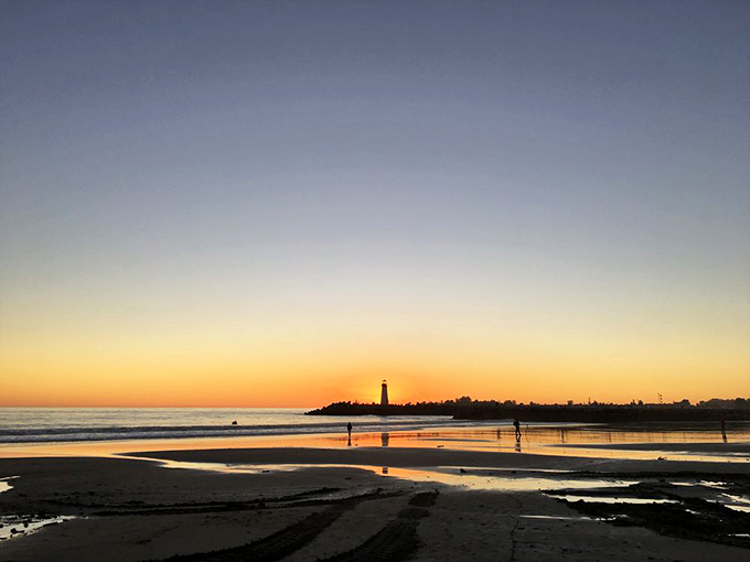 Golden hour magic transforms the lighthouse into a silhouette against the canvas of sunset, creating a moment of California coastal perfection. 