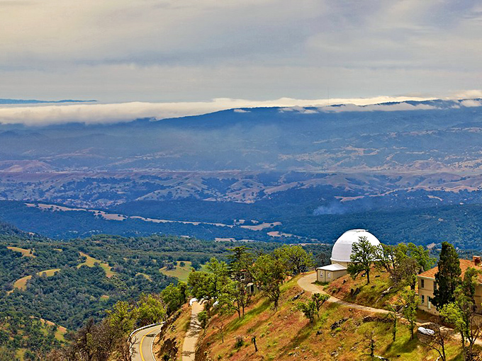 A heavenly outpost perched above it all. This white dome sentinel keeps watch over rolling California hills while fog blankets the valley like nature's own cotton candy.