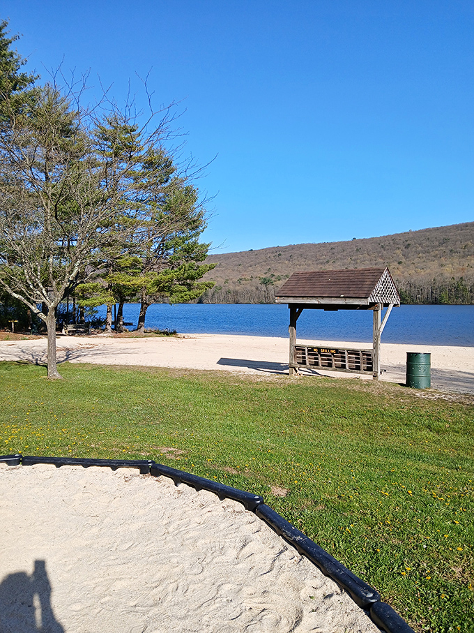 A wooden shelter stands sentinel on the shoreline, offering shade and perspective to beach-goers seeking respite from the sun.
