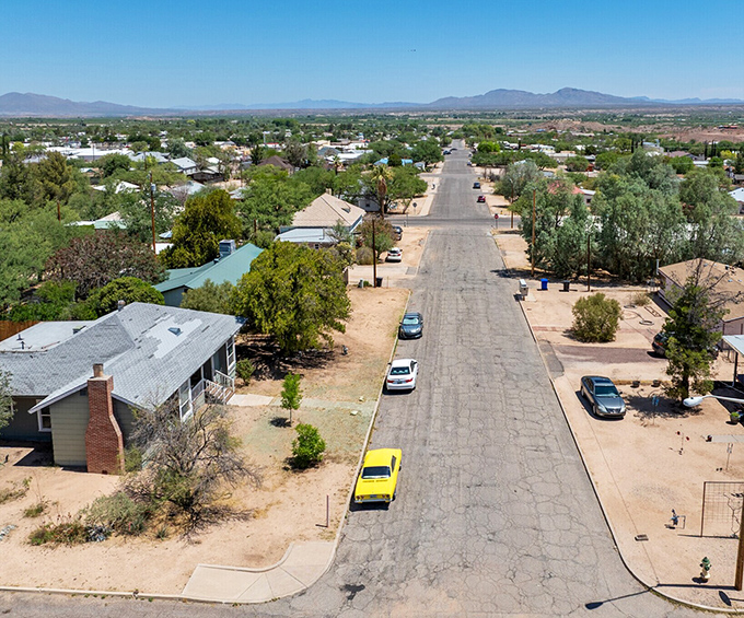 Benson's cracked asphalt tells stories of simpler times, where classic yellow cars rest easy and housing costs won't drive you to therapy.