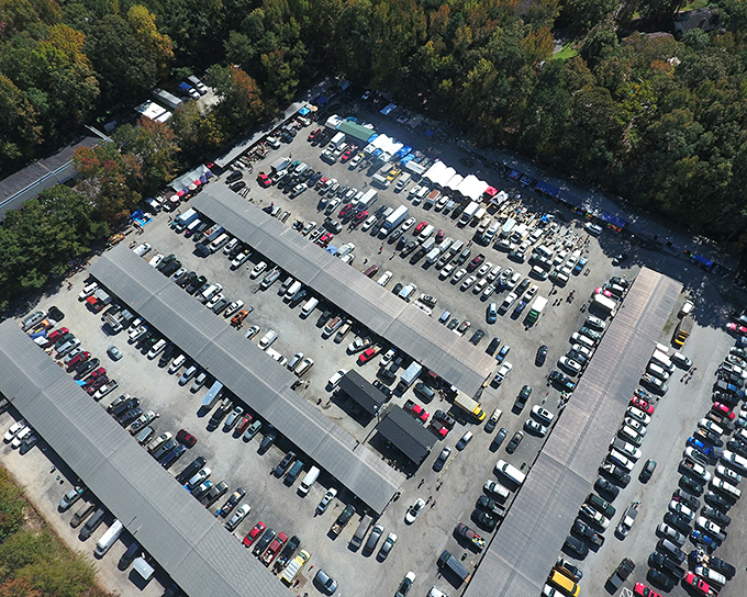 Aerial view of Bill's Flea Market showing a treasure hunter's paradise from above. Rows of covered stalls await bargain seekers like a giant board game of deals.
