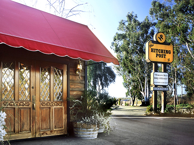 That rustic red awning has sheltered countless perfect steaks cooked over crackling oak wood fires.