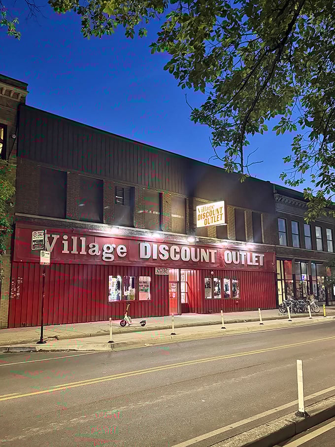 The iconic red storefront of Village Discount Outlet beckons like a beacon of bargain-hunting bliss in Chicago's night.