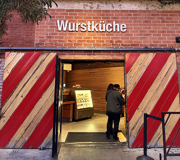 Behind those striking diagonal wood panels lies a sausage sanctuary that elevates humble hot dogs to gourmet art.