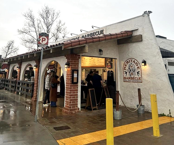 Rain or shine, Heritage Barbecue's devoted fans huddle under that terracotta awning, proving great BBQ transcends mere weather concerns.