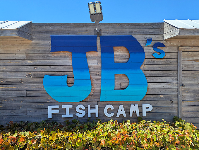 The blue "JB's Fish Camp" sign against weathered wood &ndash; nature's way of saying "authentic seafood ahead!"