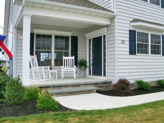 White rocking chairs standing at attention&mdash;retirement's version of a red carpet welcome. This porch practically begs for lemonade and gossip sessions.