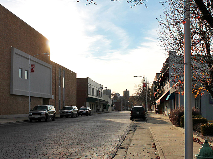 A beautiful, quiet street on a sunny afternoon, with light catching the buildings and cobblestones.